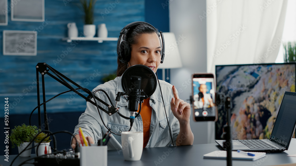 Excited famous vlogger recording video with smartphone while talking to ...