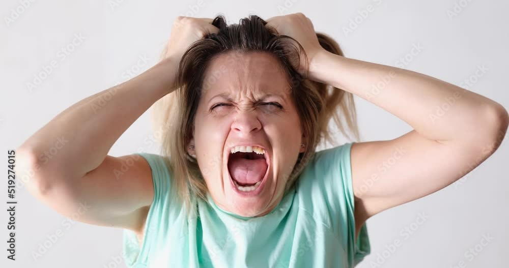 Young woman screaming and tearing her hair out on white background 4k ...
