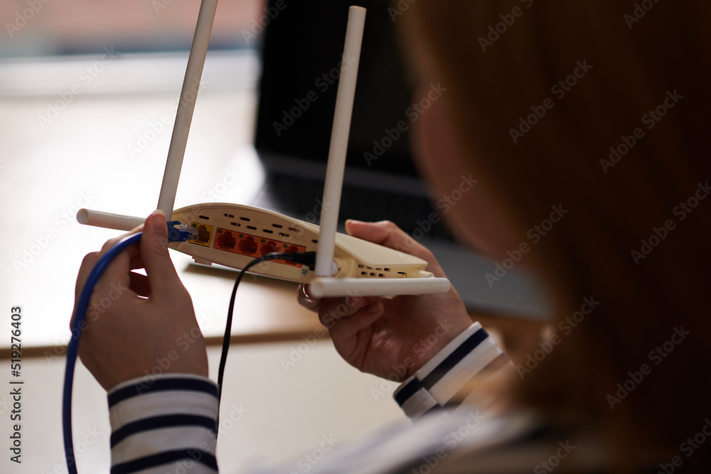 Woman plugging cord in wi-fi router to get internet access Stock Photo ...
