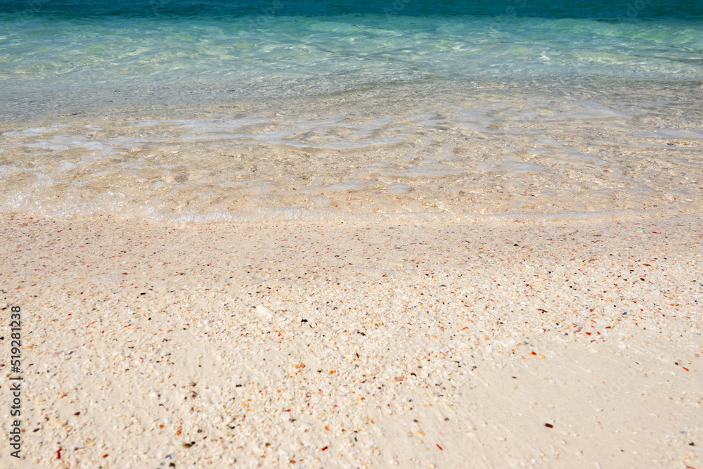 Emerald ocean with foam wave sea on bright beach and gravel texture ...