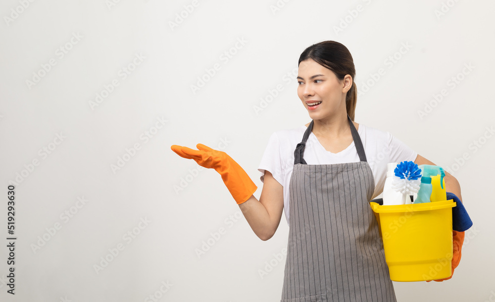 Young housekeeper woman holding bucket of cleaning products ready for ...