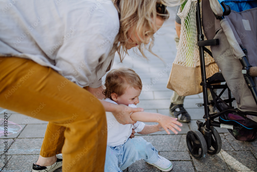Young mother comforting crying little girl outdoor on walk. Concept of ...