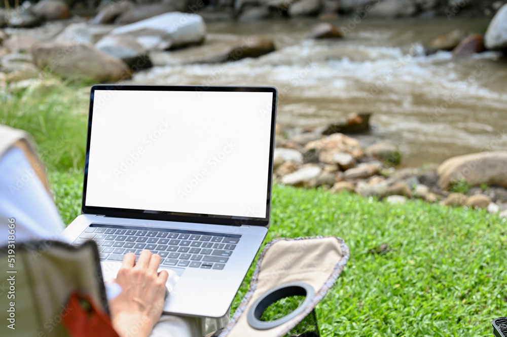 Female using notebook laptop while taking a vacation at the natural ...
