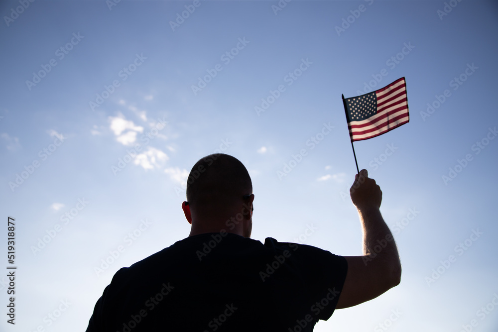 Man holding a waving american USA flag. Stock Photo | Adobe Stock