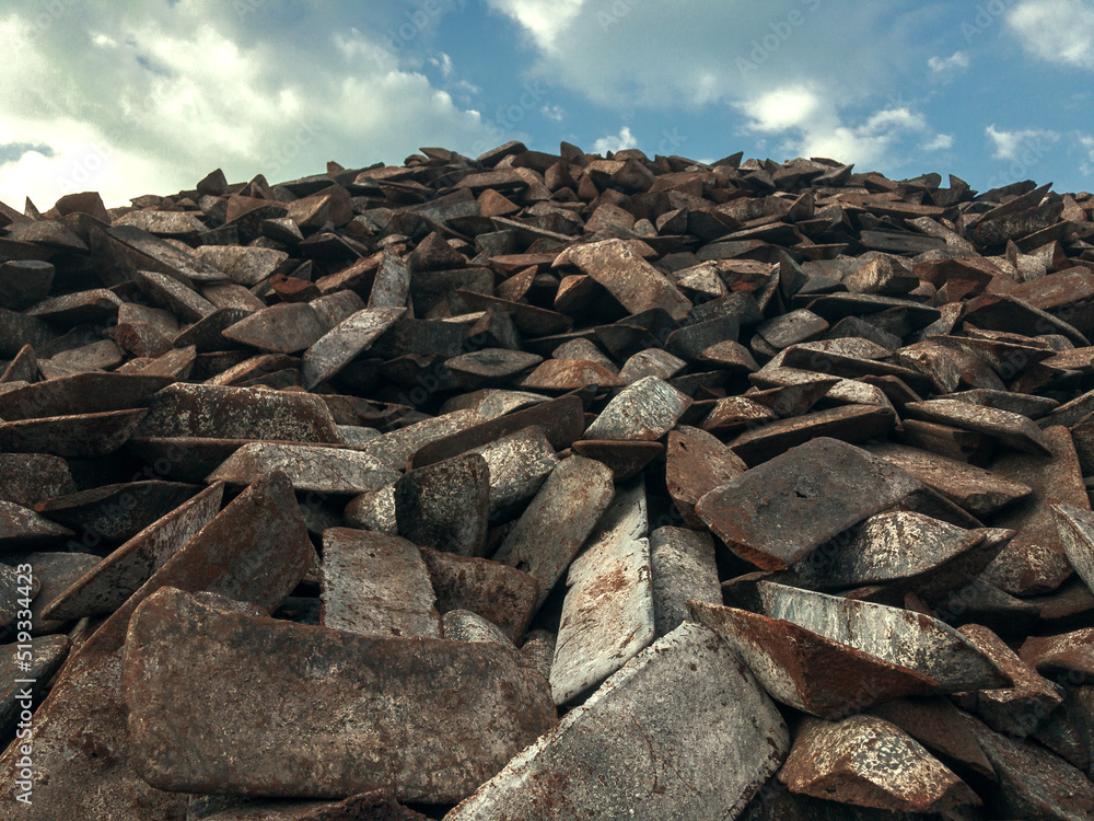 Cast iron ingots in a warehouse against a blue sky. The form of cast ...