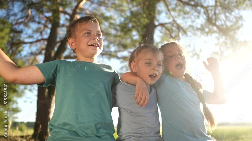 group of happy kids in the park. a team of small children hugging ...