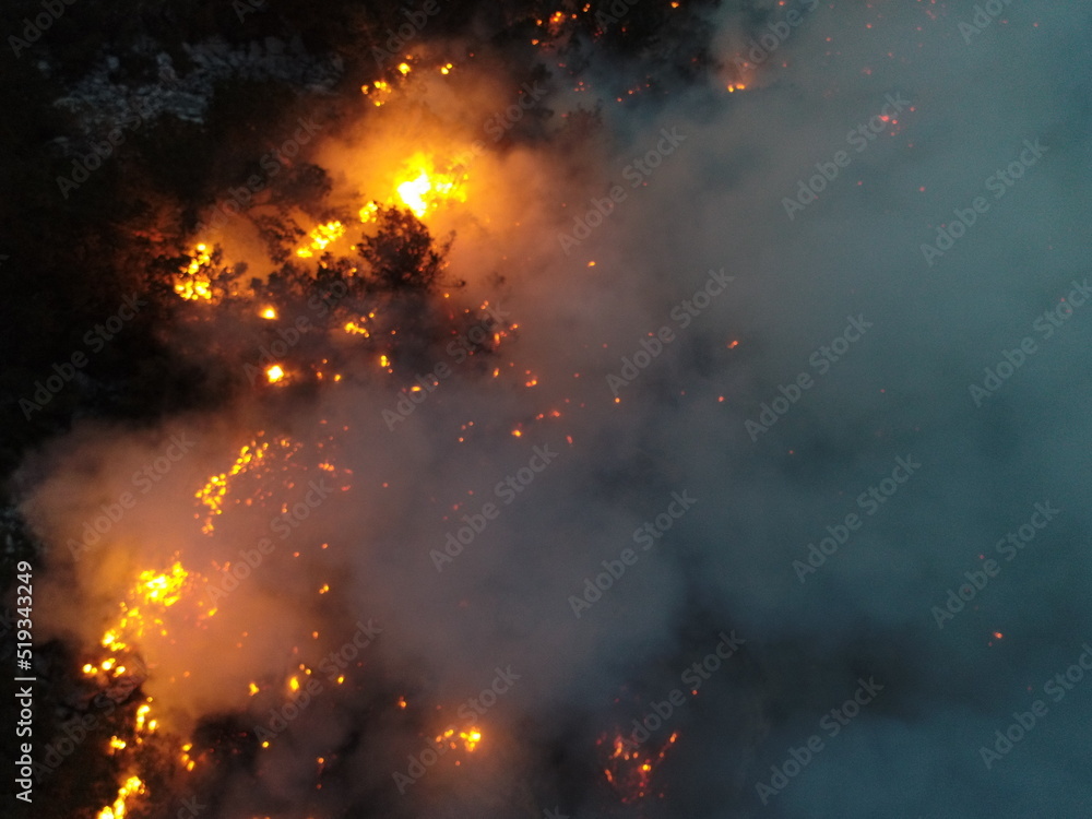 Aerial panoramic view of a forest fire at night, heavy smoke causes air ...