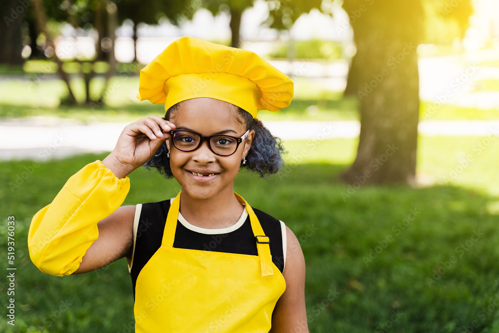 Black african child cook girl in chefs hat and yellow apron uniform ...