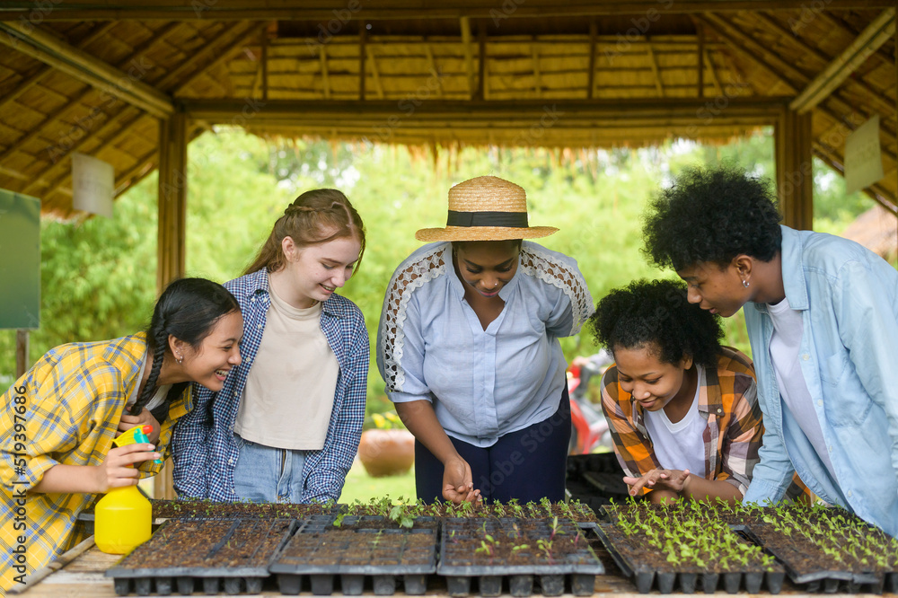 Group of mixed race students and teacher learning agriculture ...