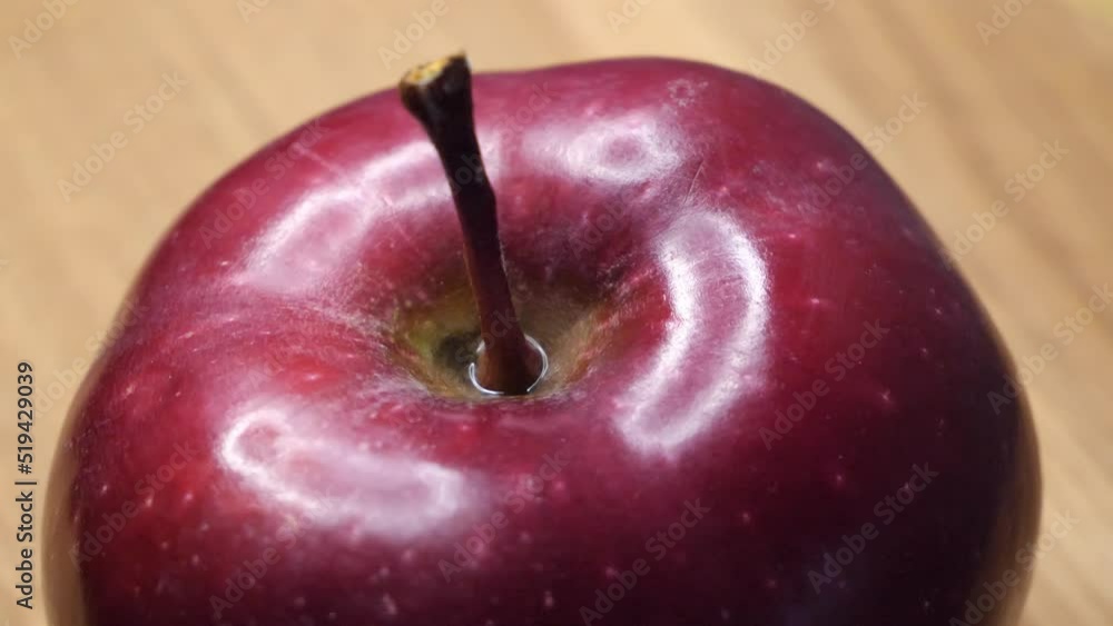 Single red apple close-up. An apple of the red chief variety rotates in ...