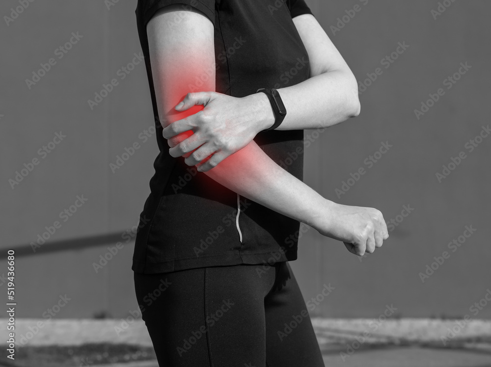 Sportswoman suffering from elbow pain with red point. Overuse ...