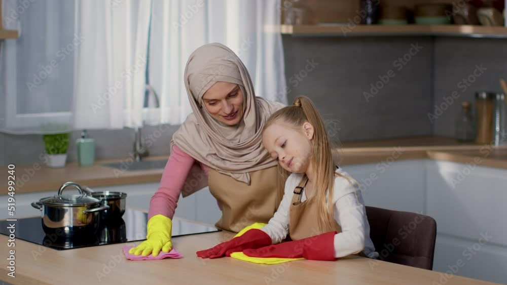 Domestic chores. Happy muslim mother in hijab and her cute little ...