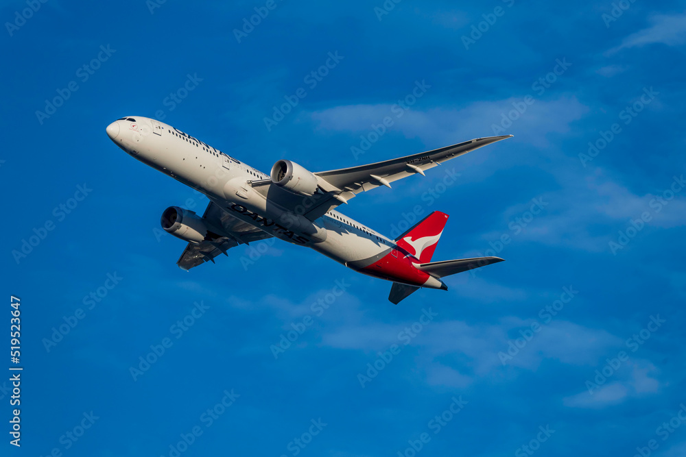 Qantas Airliner in the late afternoon blue sky with light white high ...