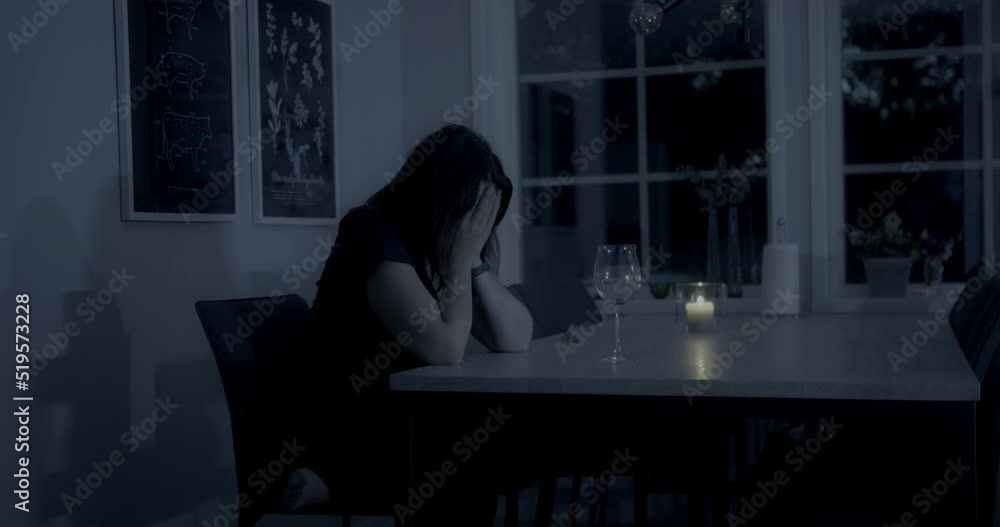 Sad girl cries at dinner table with empty wine glass, pan reveals empty ...