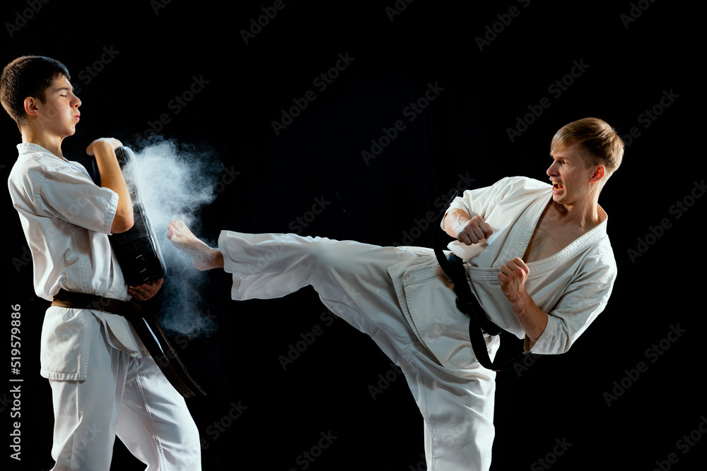 Dynamic portrait of male karate-do fighters in sports uniform training ...