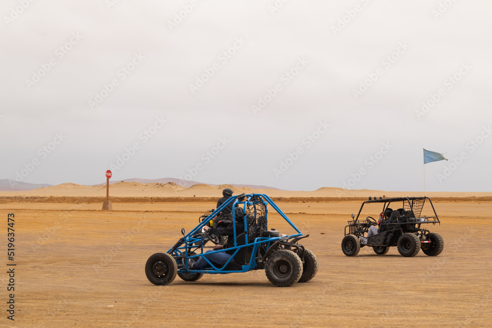 Men driving two quads, buggies, buggy through the Paracas National ...