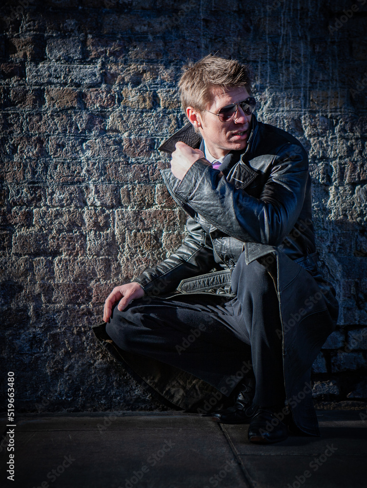 Undercover; in the shadows. A spy hiding in the shadows looking over ...