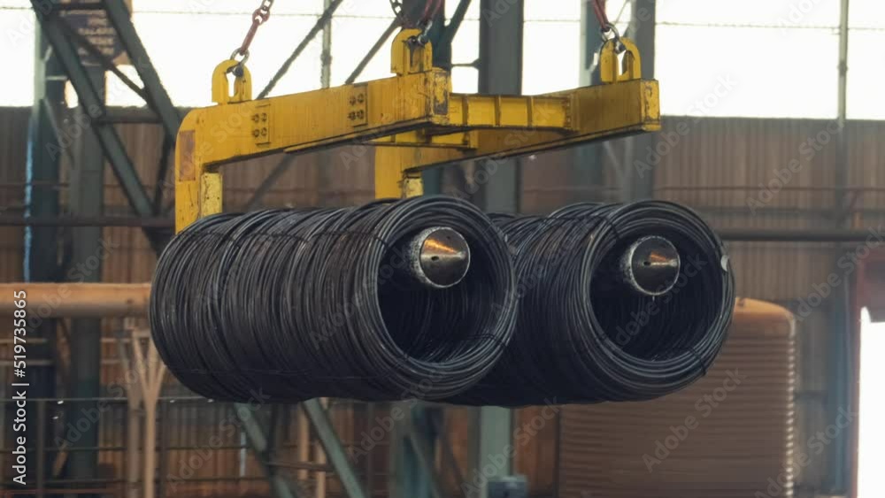 Overhead crane carrying steel cable inside factory. Working process at ...
