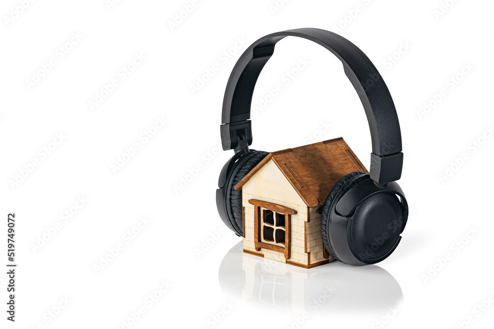Black wireless headphones on a small wooden house isolated on white ...