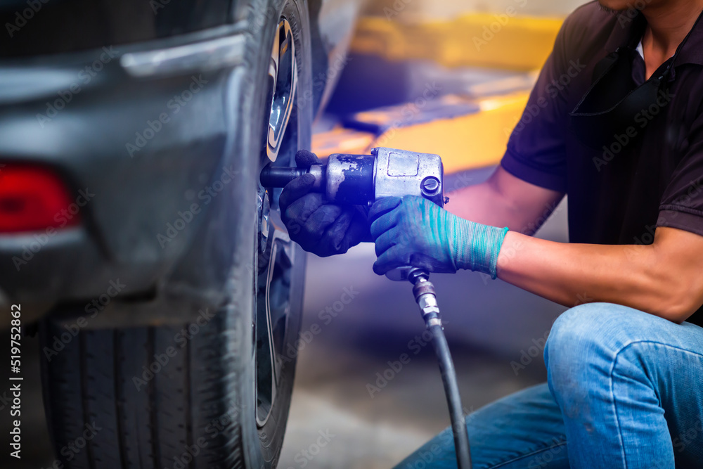 Selective focus to impact air wrench in hand of professional car ...