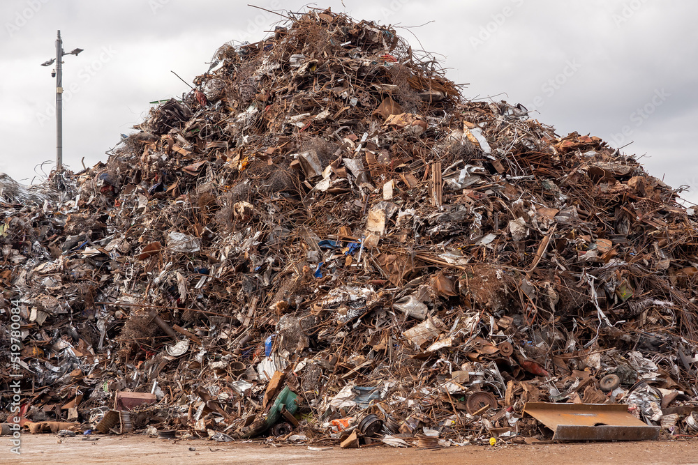 Huge pile of different scrap metal in a junk yard ready for export and transportation. Recycling ...