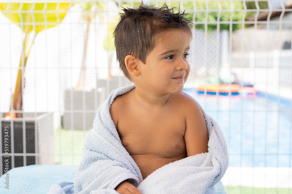Cute smiling little boy sitting near outdoor swimming pool foto de ...