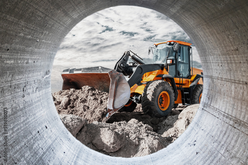 Bulldozer or loader moves the earth at the construction site against ...