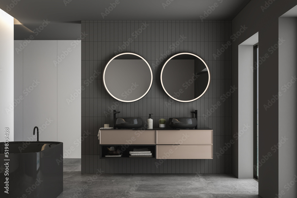 Dark bathroom interior with concrete floor, black bathtub and oval ...