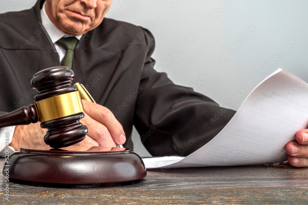 judge's gavel on the table. Judge signing verdict. Law Lord wearing ...