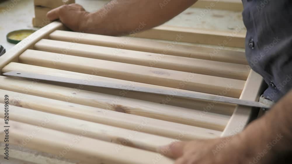 Stockvideo The carpenter in this workshop assembles a handmade chair ...