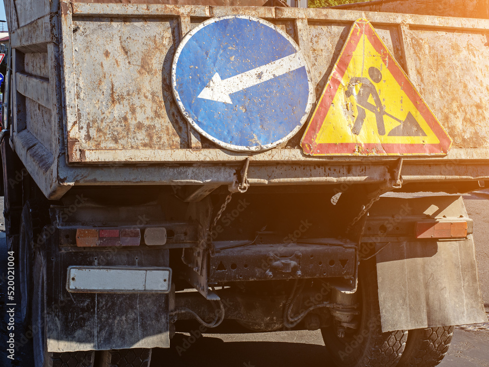 Truck sign roadworks. There are warning signs on the back of the truck ...