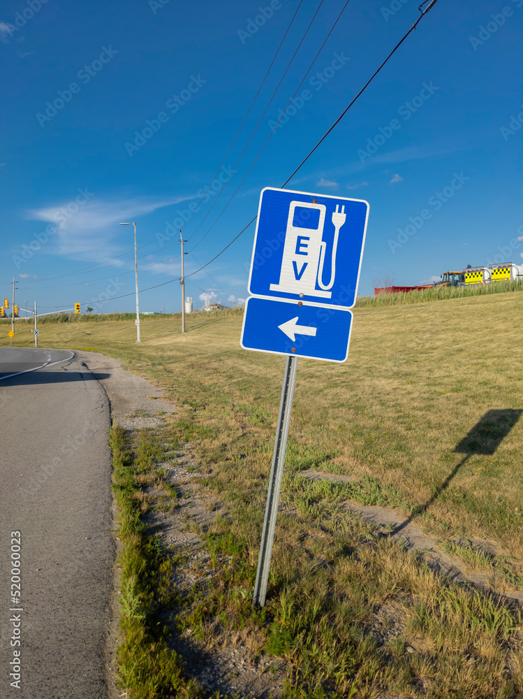 Road sign EV with direction arrow for the electrical vehicle chargers ...