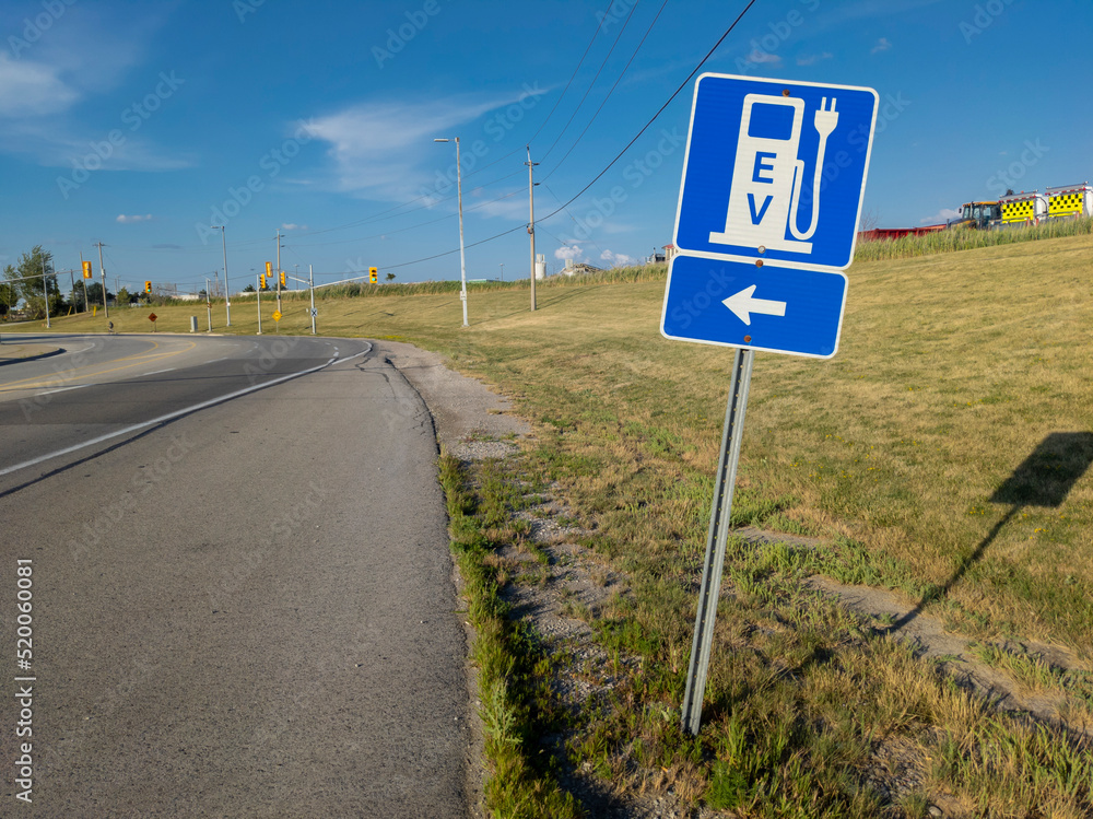 Road sign EV with direction arrow for the electrical vehicle chargers ...