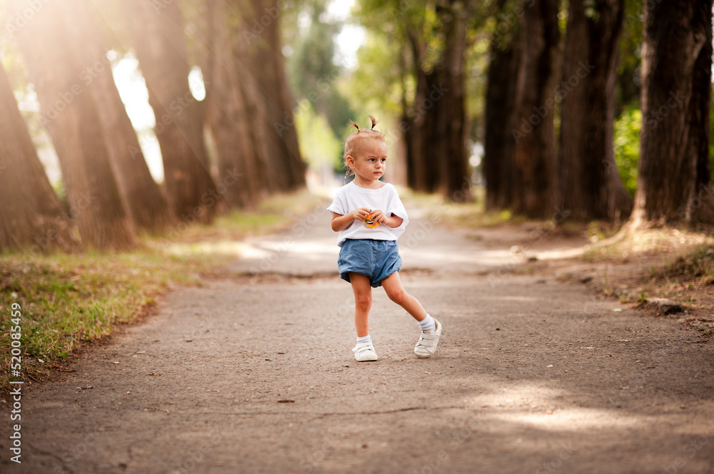 One young little child walking, strolling through a green field, rural ...