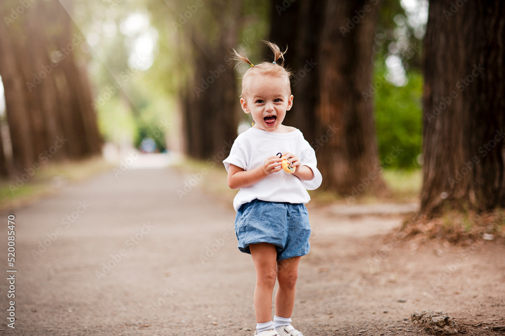 One young little child walking, strolling through a green field, rural ...