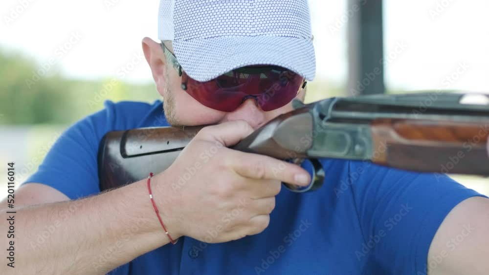 Sportsman shoots from a double-barreled shotgun, A sports field for a ...
