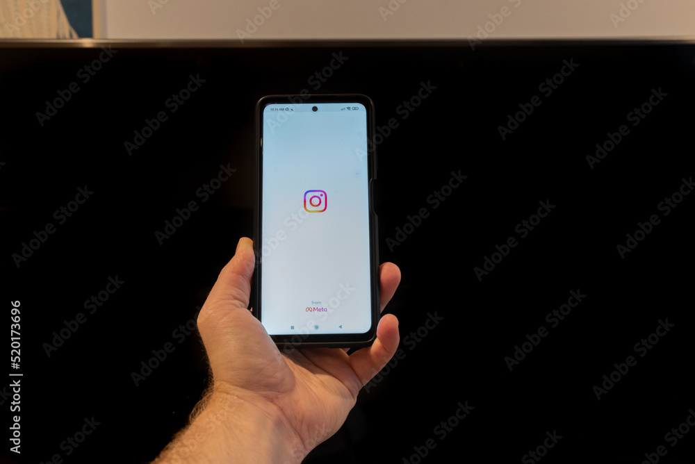 a hand hold up an illustration of the instagram logo displayed on a ...