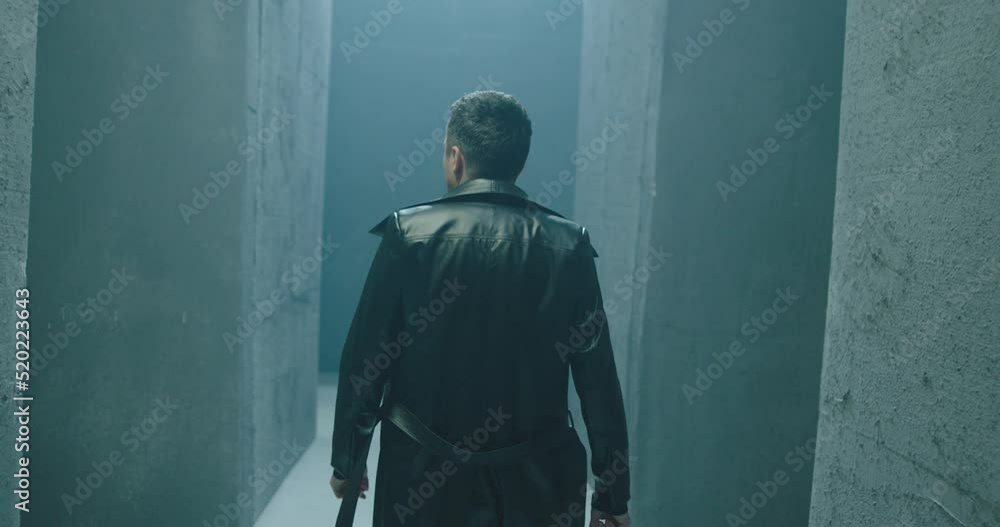 Rear back view of unknown man walking , standing or running inside dark ...