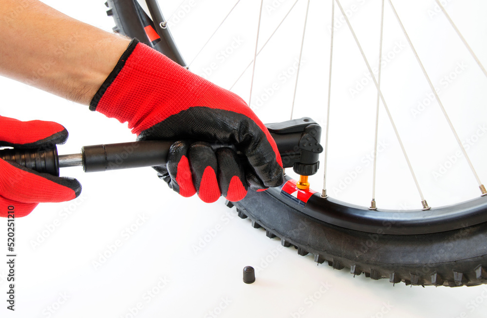 inflate a flat tire of a bicycle with a hand pump, close-up, on an ...