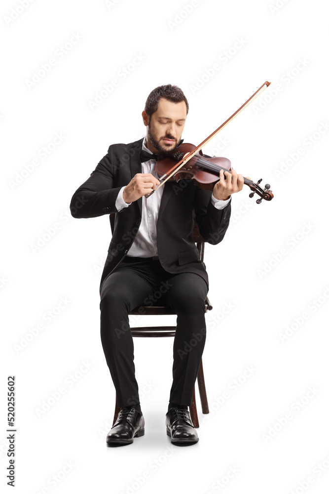 Full length portrait of an elegant young man sitting and playing a ...