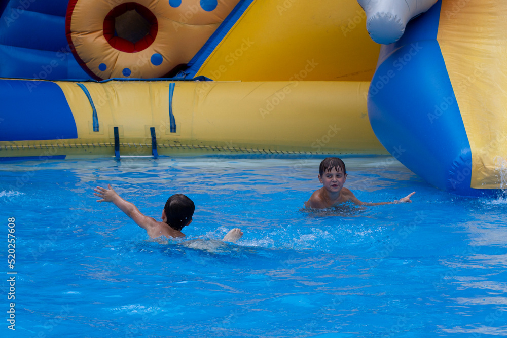 Children play and swim in pool. Two children are having fun in pool ...