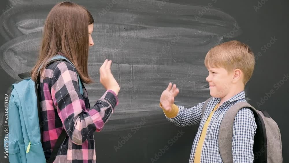 Two happy Kids on first school day on blackboard background. Cute ...