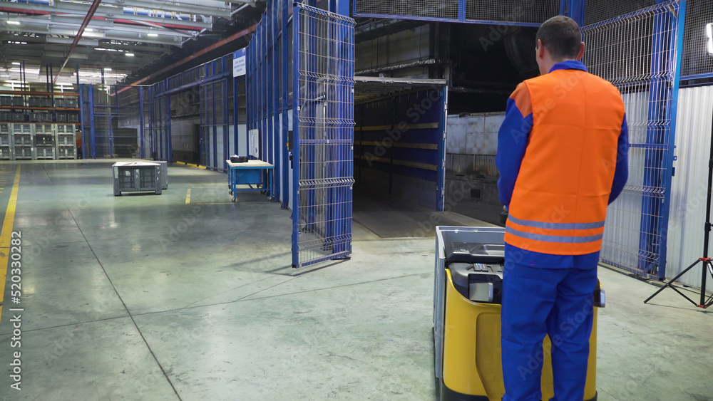 Worker on loader transports boxes in warehous. Scene. Worker standing ...