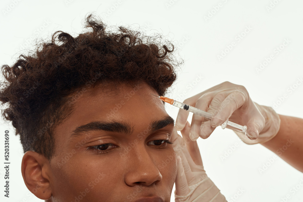 Doctor making injection with syringe on guy face Stock Photo | Adobe Stock