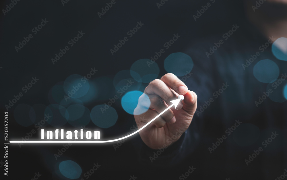 Trader hand writing increasing white arrow with inflation wording for ...