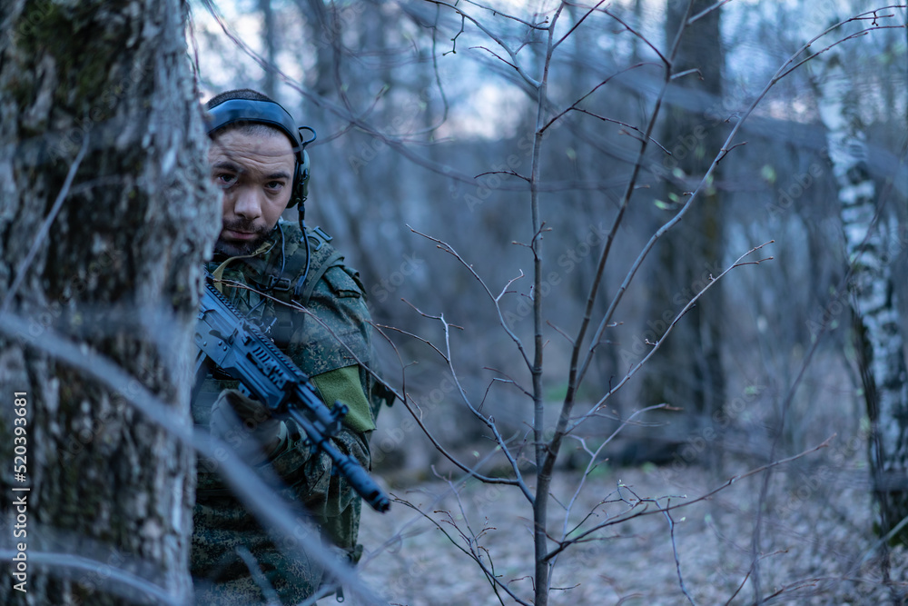 soldier in the forest. a man in military uniform in the branches of ...