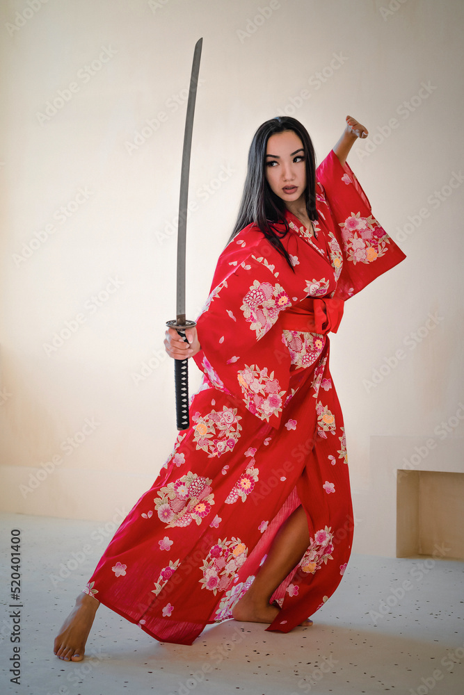Young beautiful asian girl in the red kimono with the katana sword ...