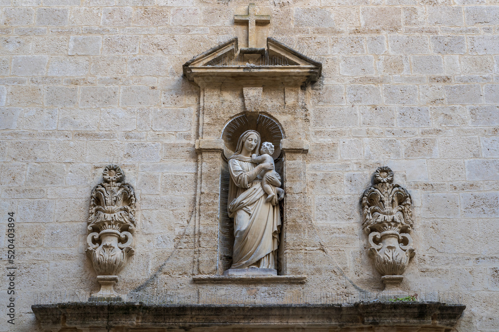Detail of the facade of the ancient dominican convent with stone statue ...