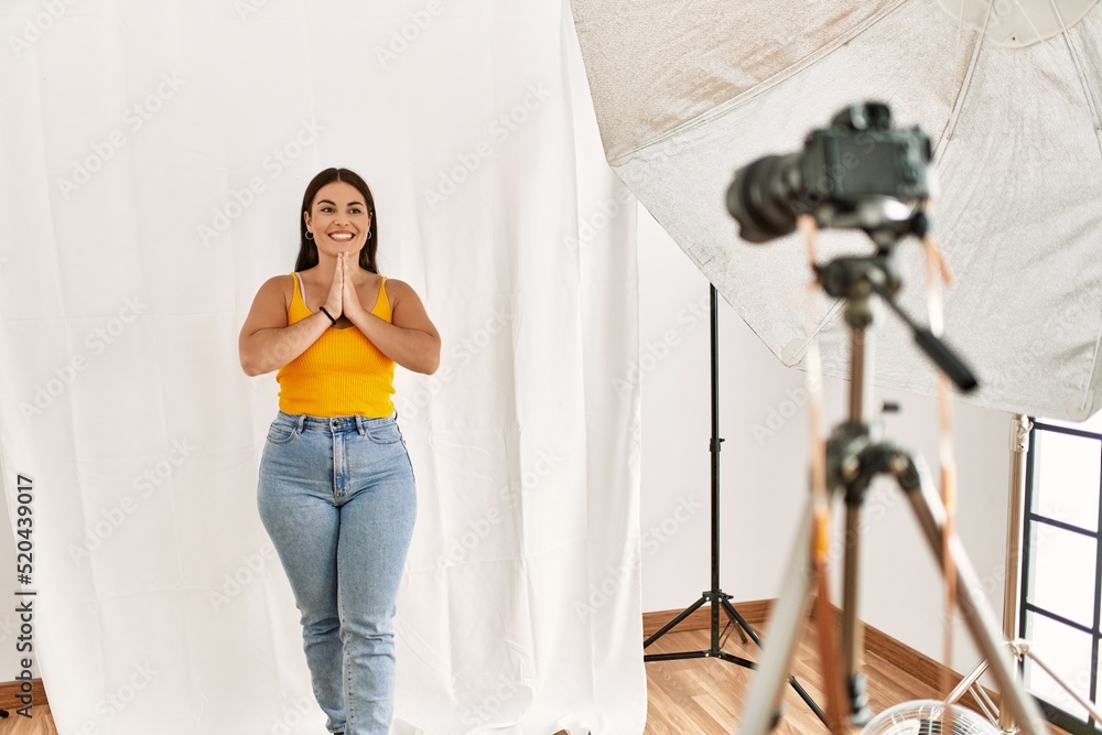Young beautiful hispanic woman posing as model at photography studio ...