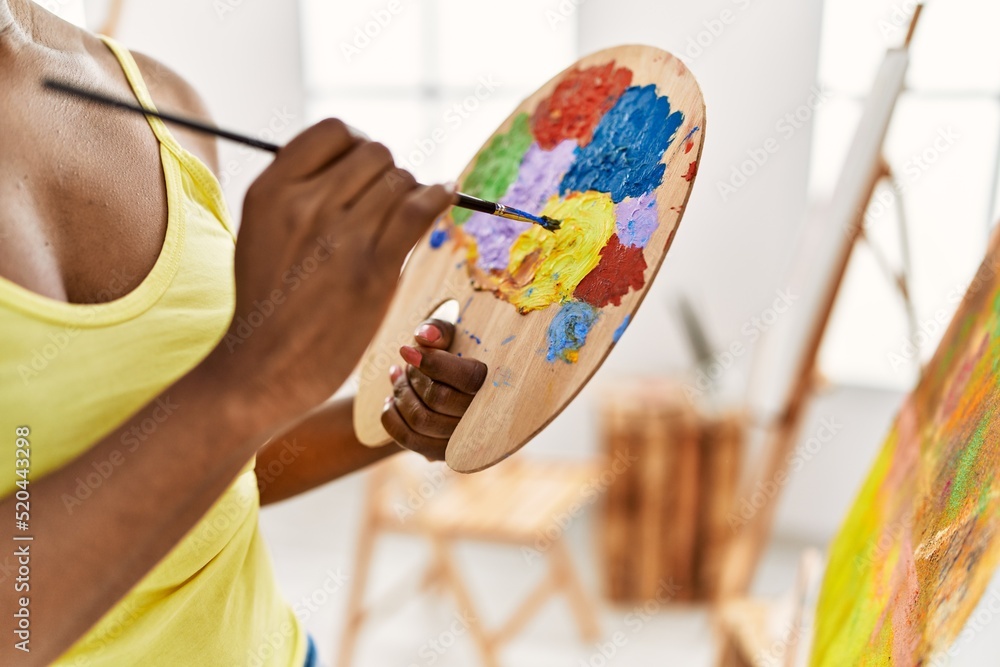 African american artist woman mixing color on palette at art studio ...